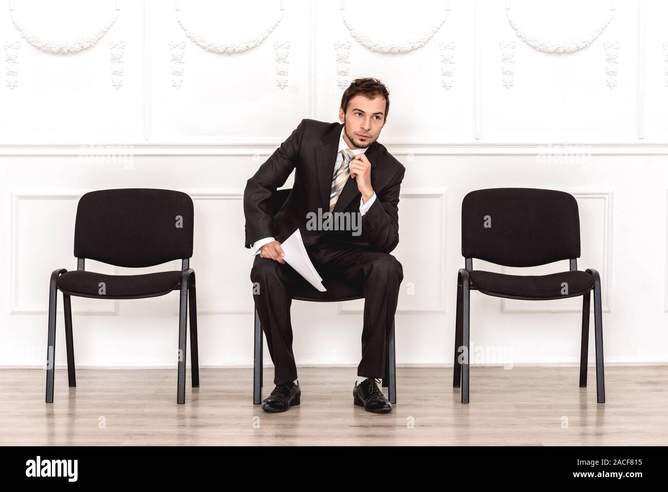 Job interview. Man sitting isolated on white waiting with resume ...