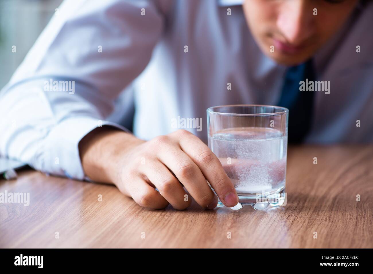 The sick male employee suffering in the office Stock Photo - Alamy