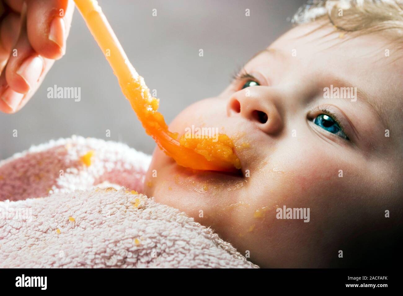 Spoon-feeding. Baby being spoon-fed by his father Stock Photo - Alamy
