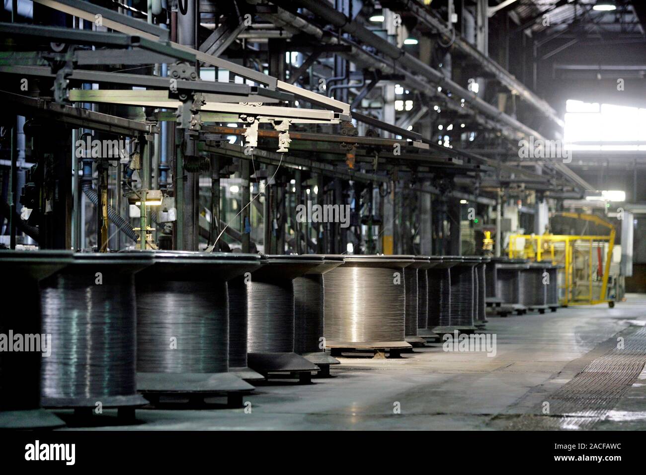 Security fencing production. Large reels of metal wire in a factory ...