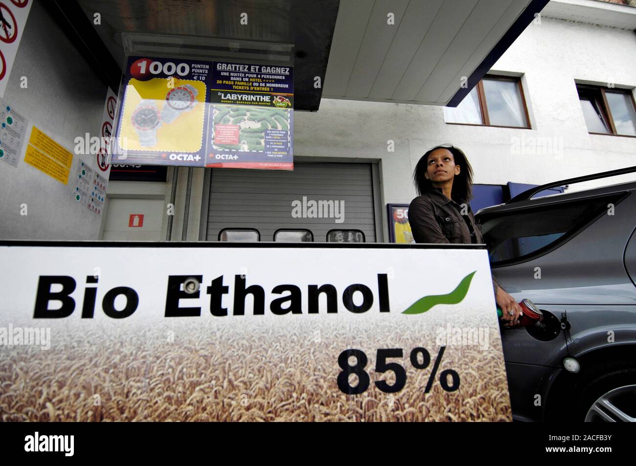 Biofuel pump. Woman filling up a car with bioethanol. This fuel is a ...