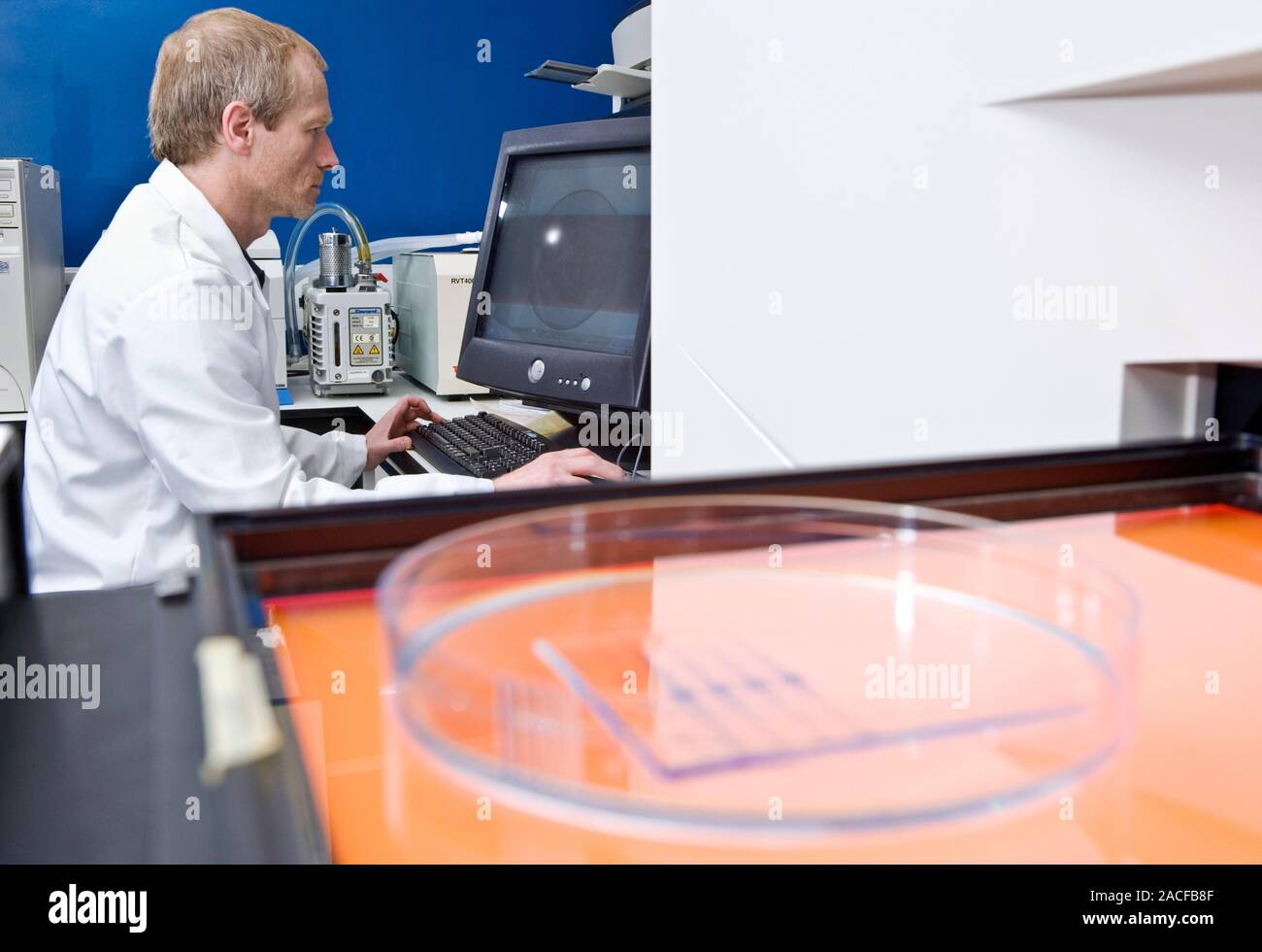 Protein analysis. Technician using a proteomics imaging system to ...