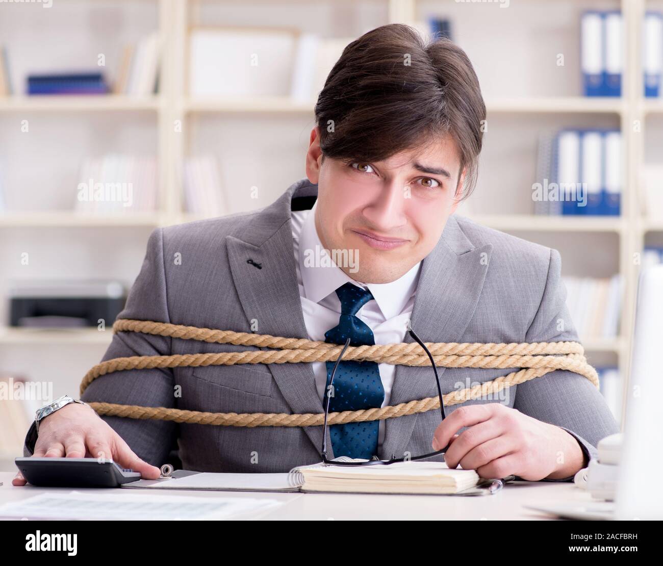 The businessman tied up with rope in office Stock Photo - Alamy