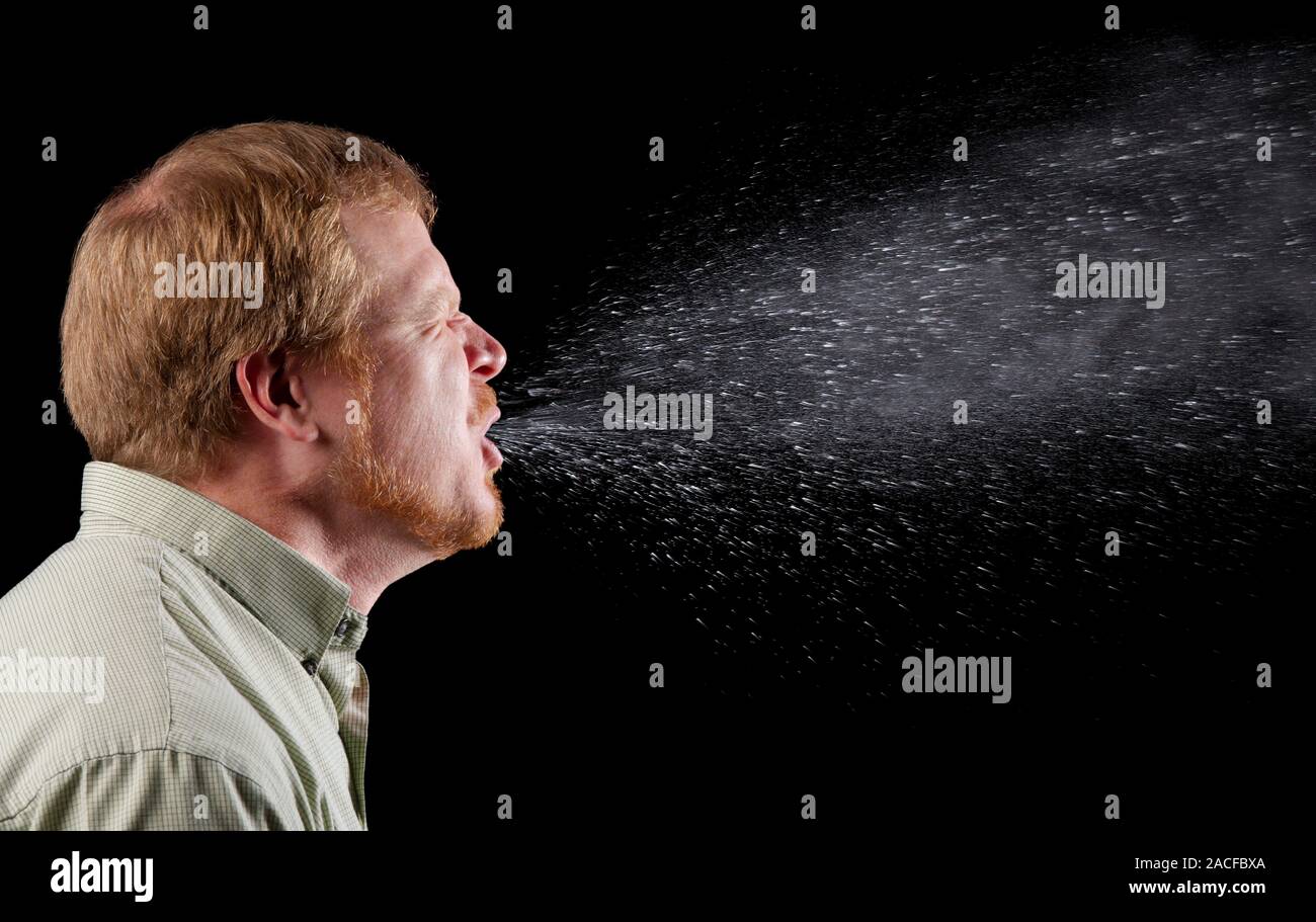 Man sneezing. High speed photograph of a man sneezing, showing a plume ...