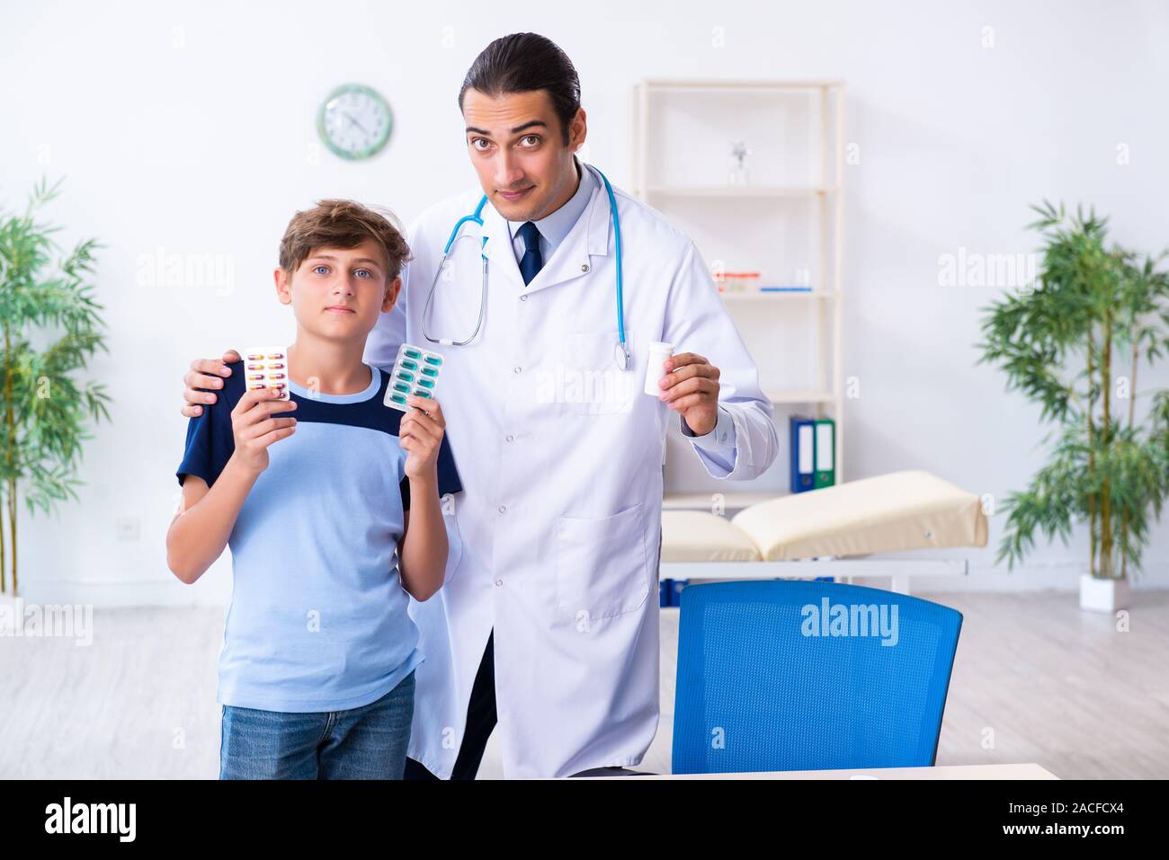 The young male doctor examining boy in the clinic Stock Photo - Alamy