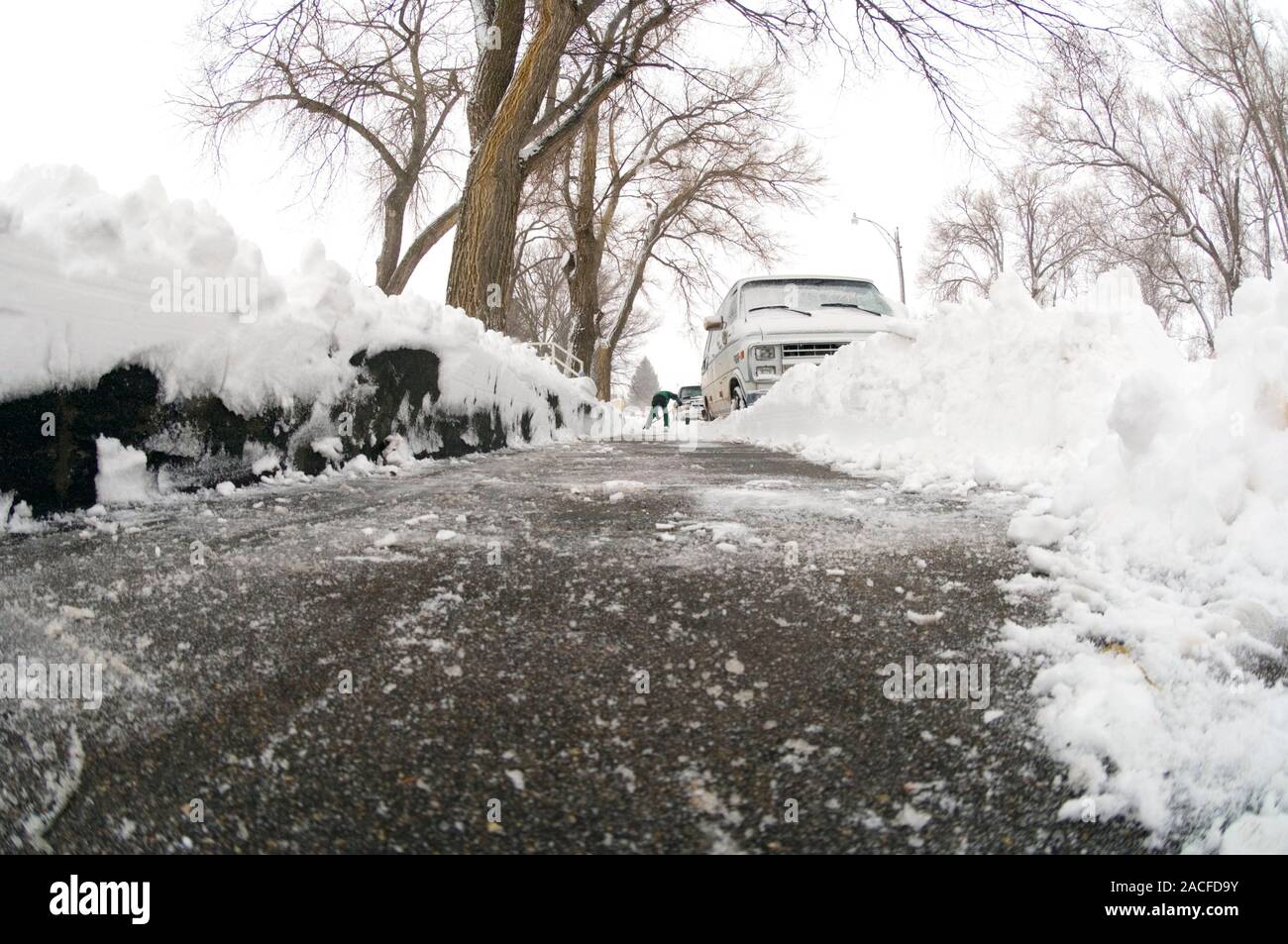Snow clearing. Person clearing snow from a pavement shortly after a ...
