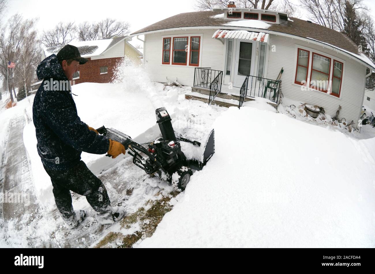 Snow clearing. Man pushing a snow-blower in an effort to remove snow ...