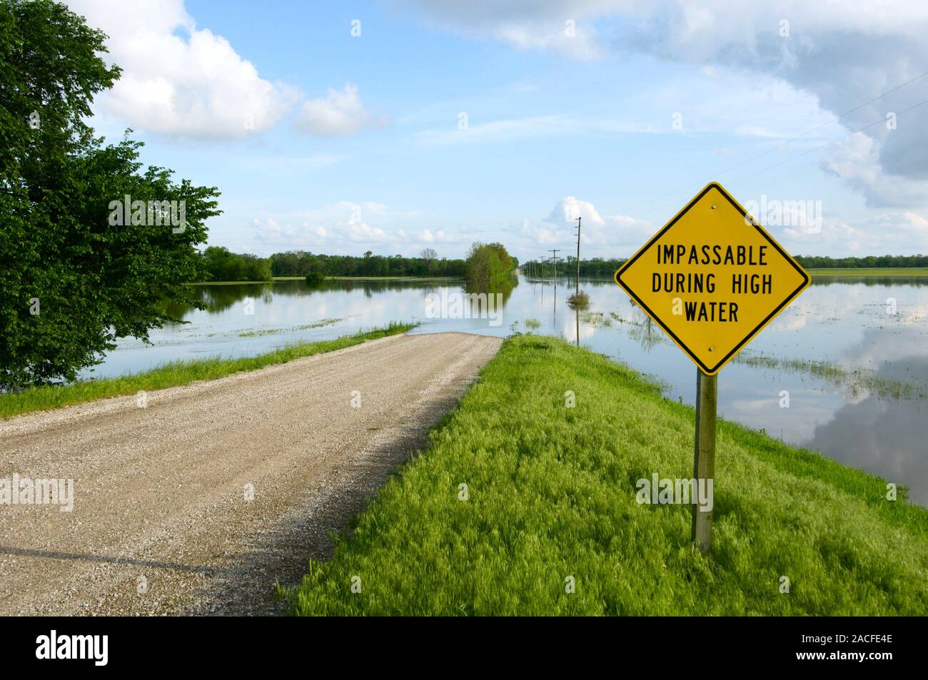 Impassable flooded road. Flooded road with a sign warning motorists ...