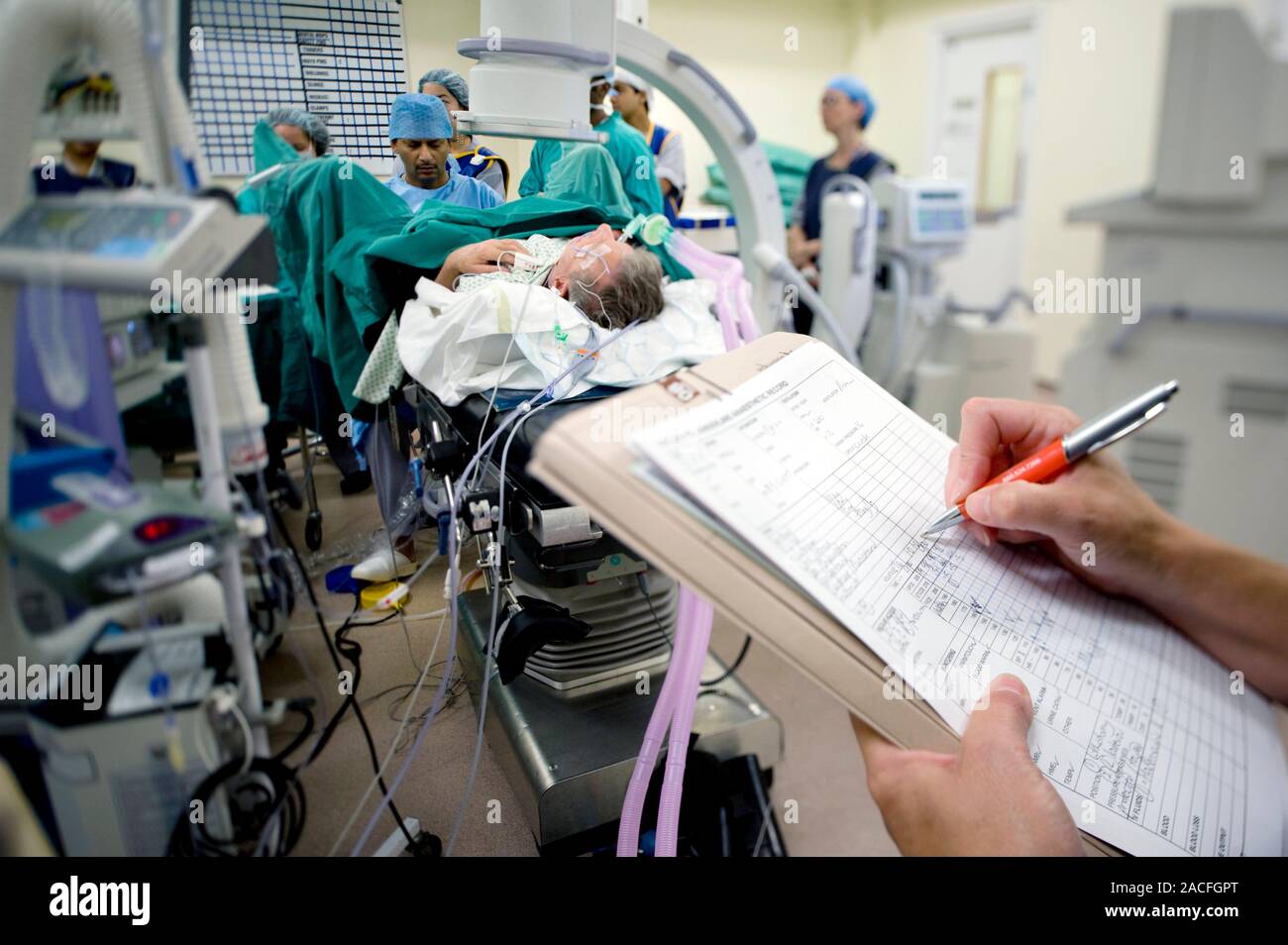 Surgical note-taking. Theatre assistant taking notes during an ...