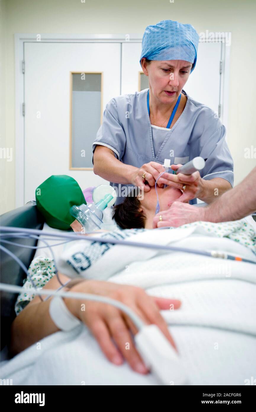 Intubating a patient. Doctor inserting a breathing tube into a patient ...