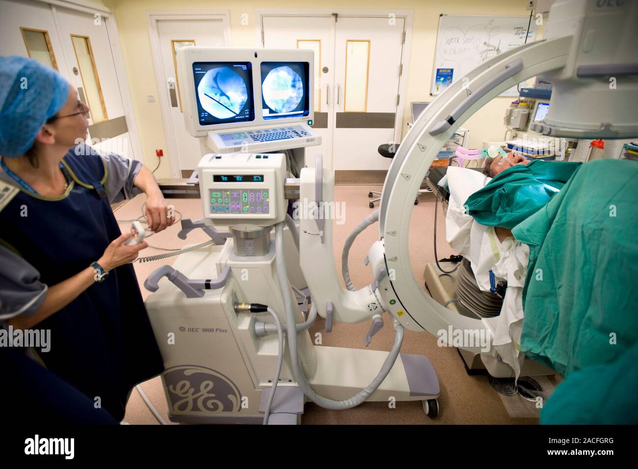 Surgical X-raying. Radiologist using an X-ray machine to take pictures ...