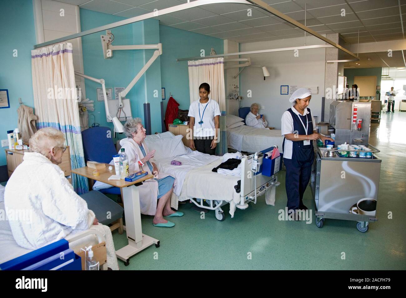 Hospital ward. Tea lady preparing drinks on a hospital ward while a ...