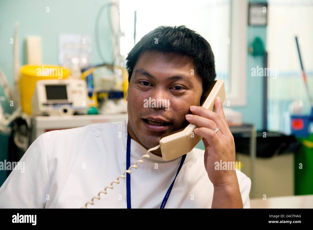Hospital nurse. Staff nurse talking on a telephone. Photographed at the ...