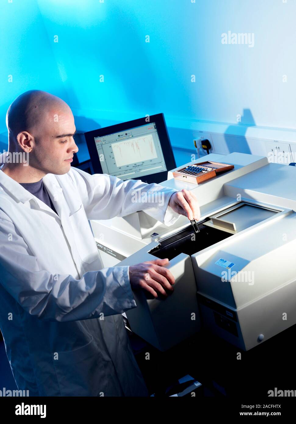 Spectrophotometry research. Technician using a spectrophotometer to ...