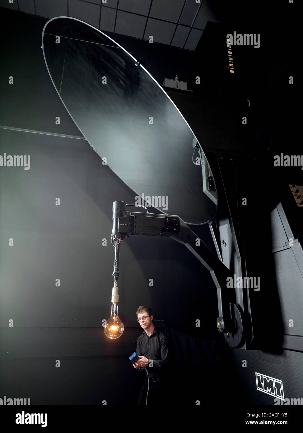 Measuring light intensity. Researcher aligning a flux reference standard lamp for calibration on ...