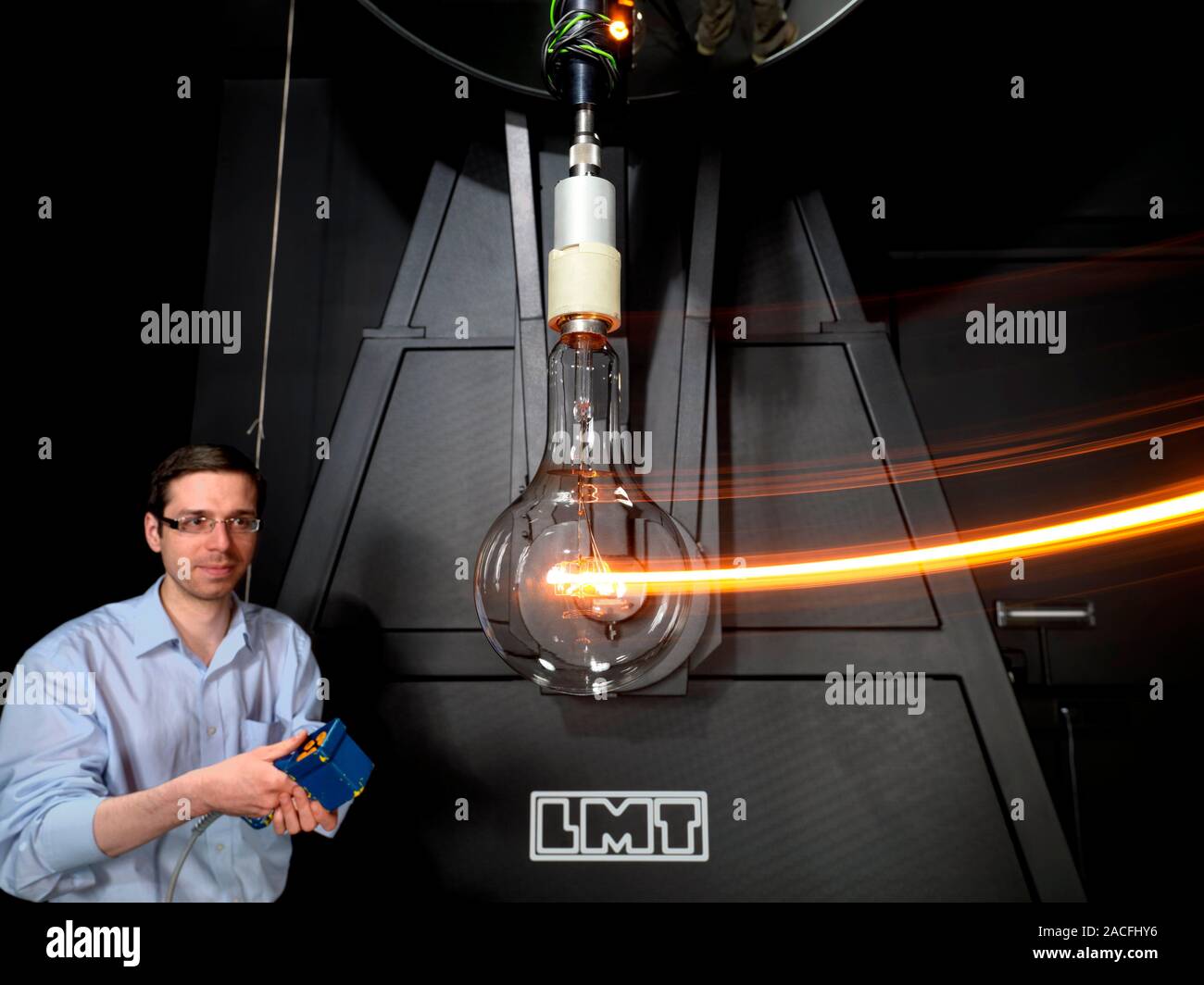 Measuring light intensity. Researcher aligning a flux reference standard lamp for calibration on ...