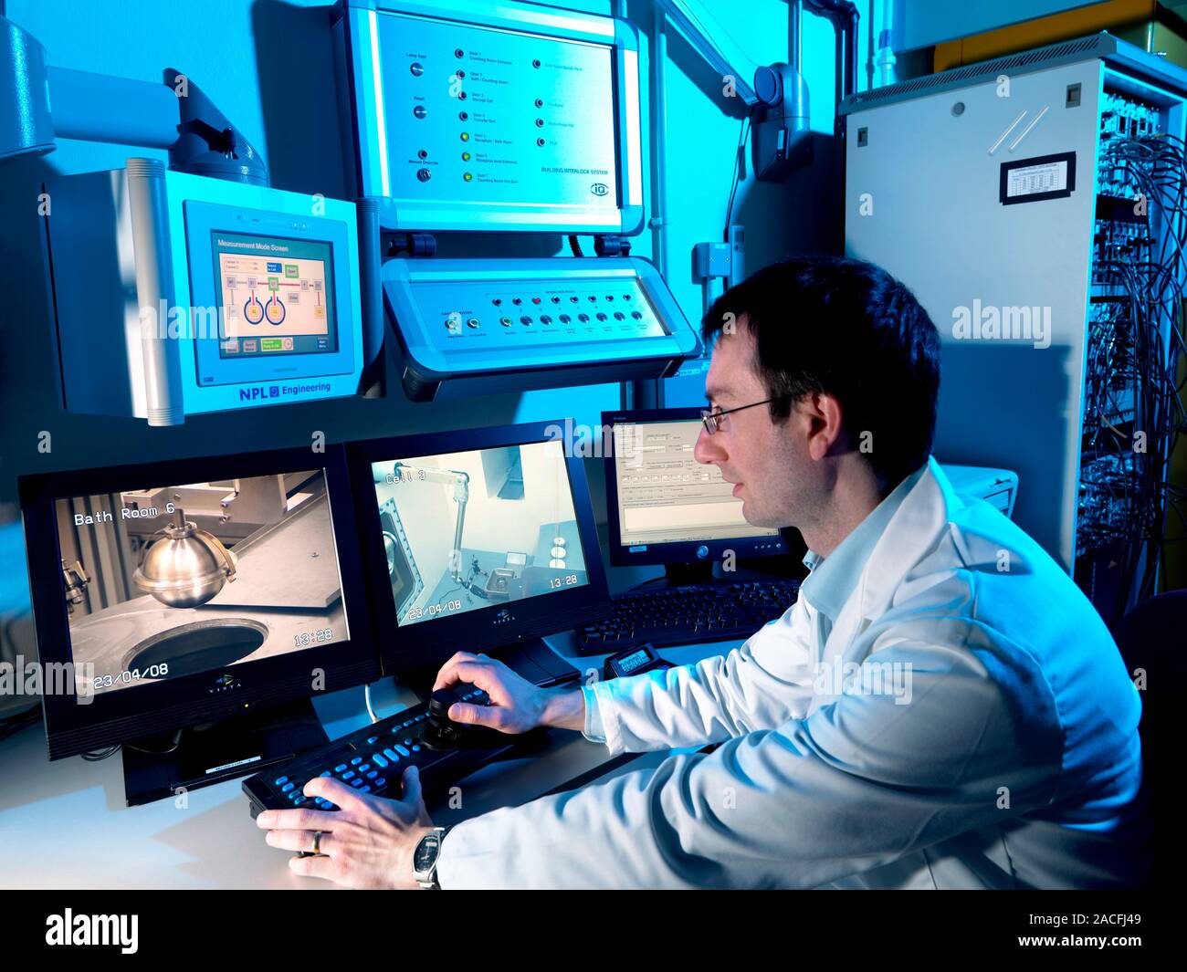 Using a manganese bath. Physicist in a control room remotely using an ...