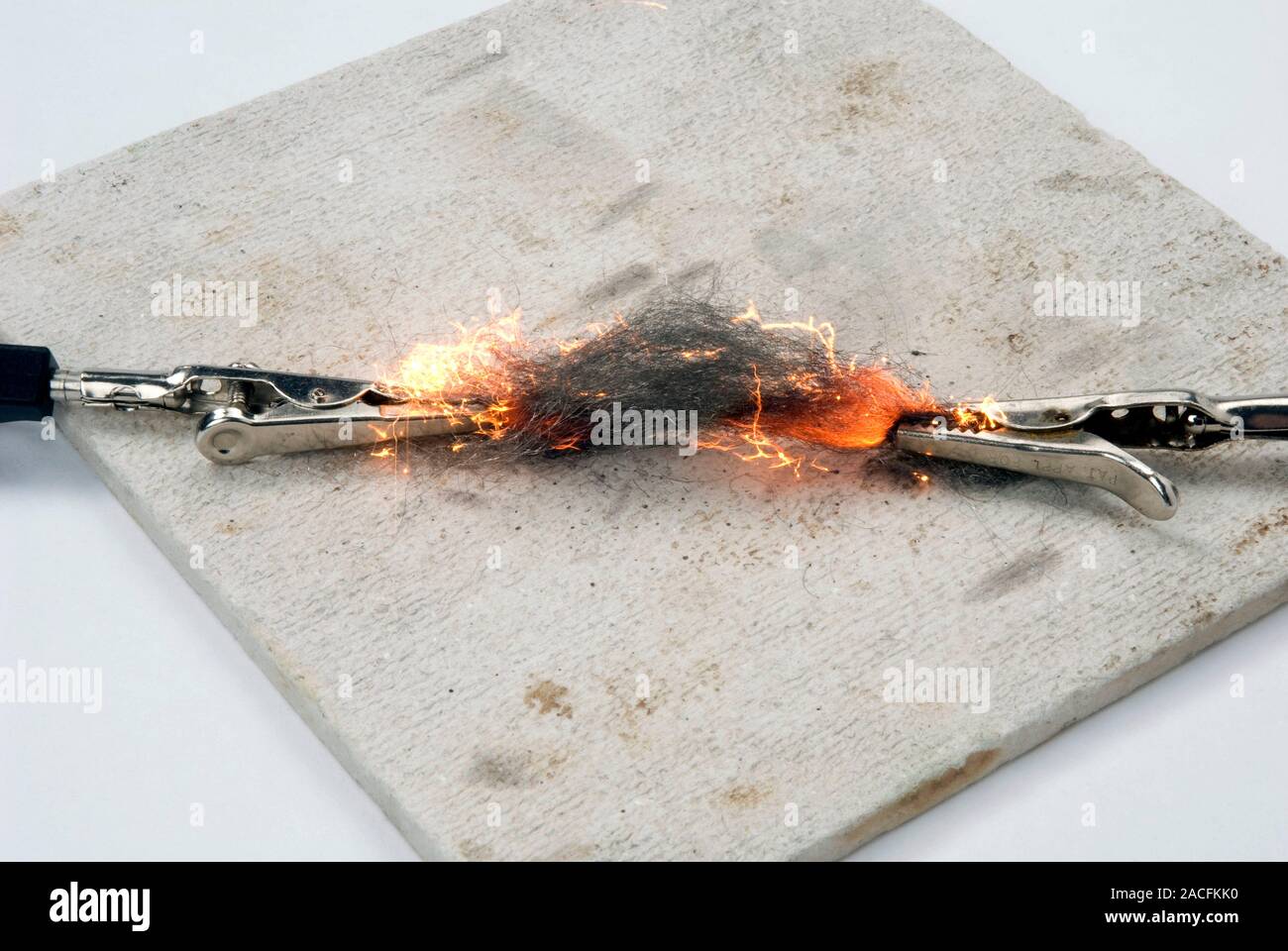 Current melting steel wool. Steel wool attached between two pieces of ...