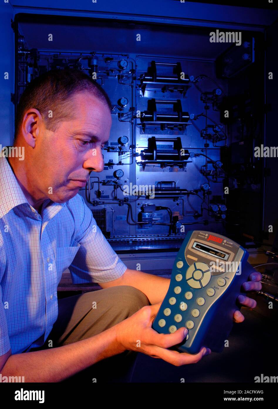 Liquefied natural gas (LNG) sampling system. Technician holding part of ...