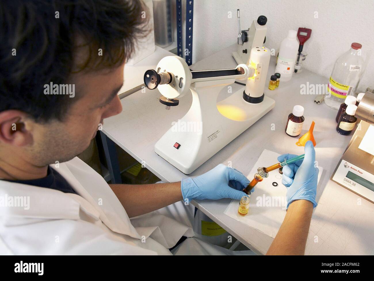 Essential oils manufacture. Technician using a polarimeter to determine ...