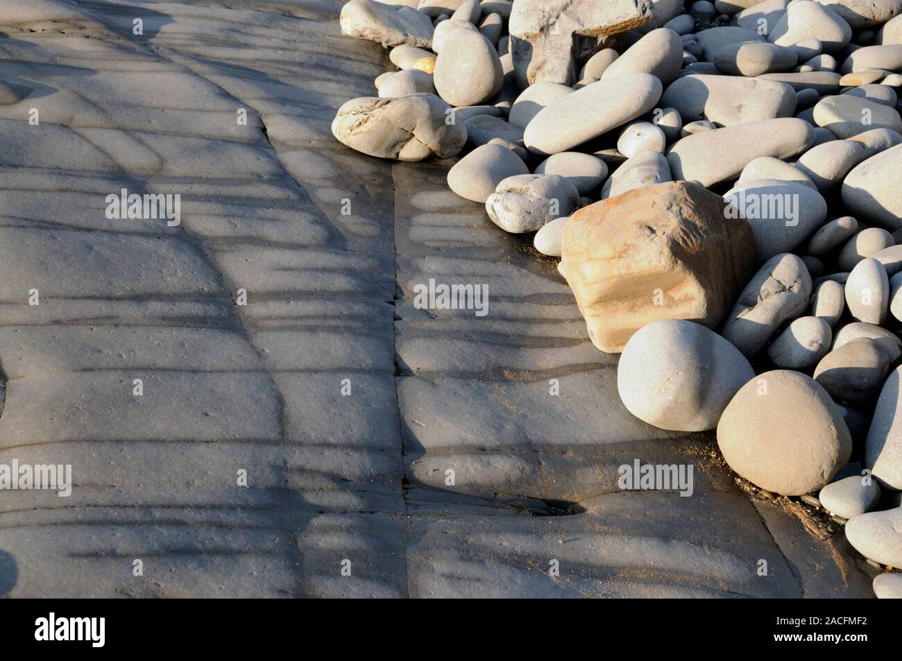 Sandstone rock at low tide. Moisture left by a receding tide highlights ...