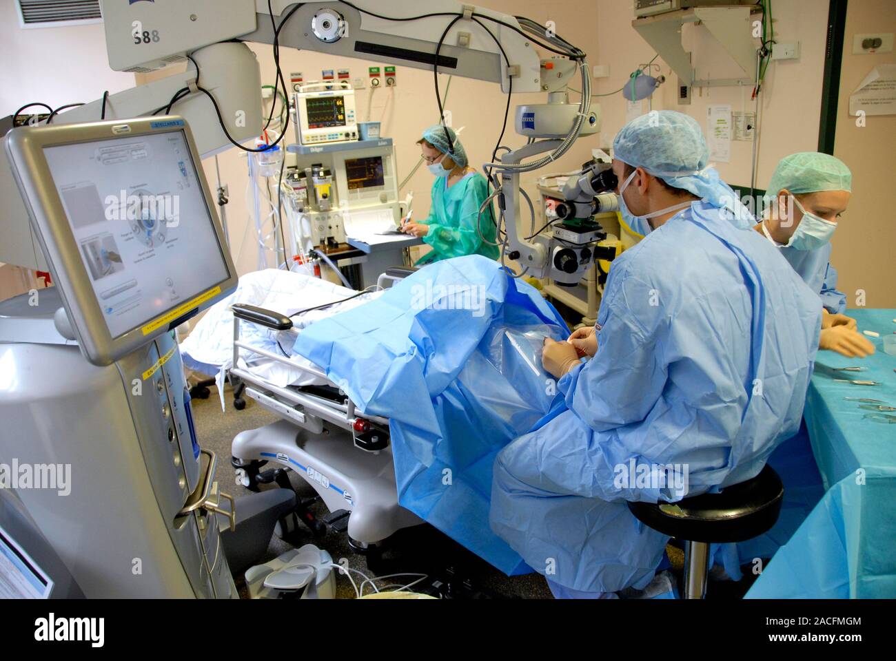 Eye cataract surgery by phacoemulsification. A surgeon (foreground ...