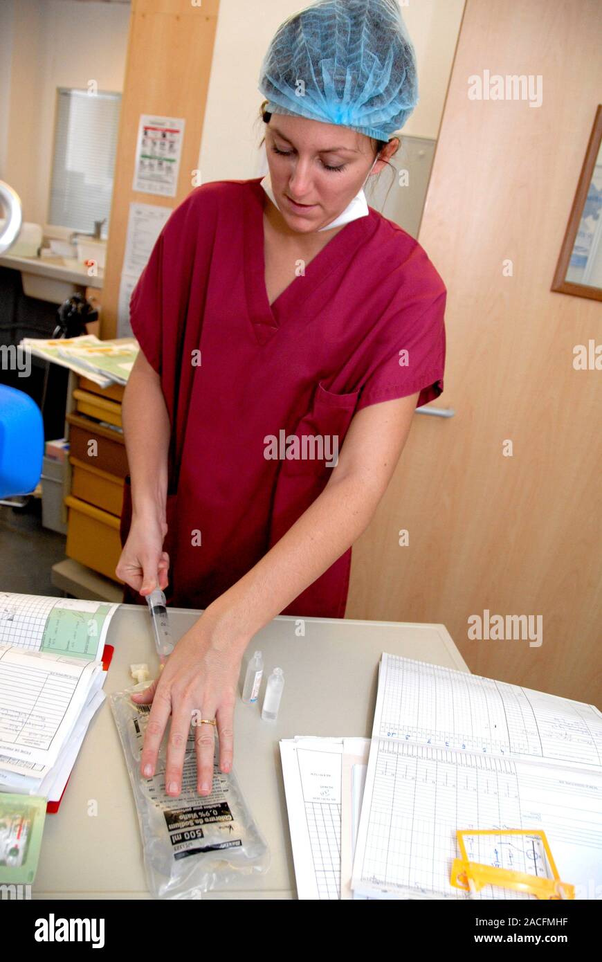 Nurse preparing intravenous medication in an intensive care unit ...