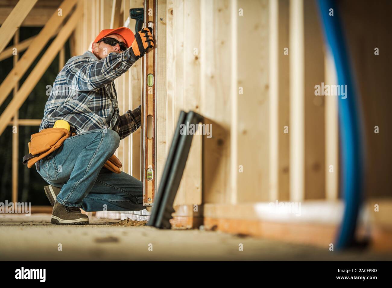 Caucasian Contractor Worker with Spirit Level Making Sure Wooden House ...