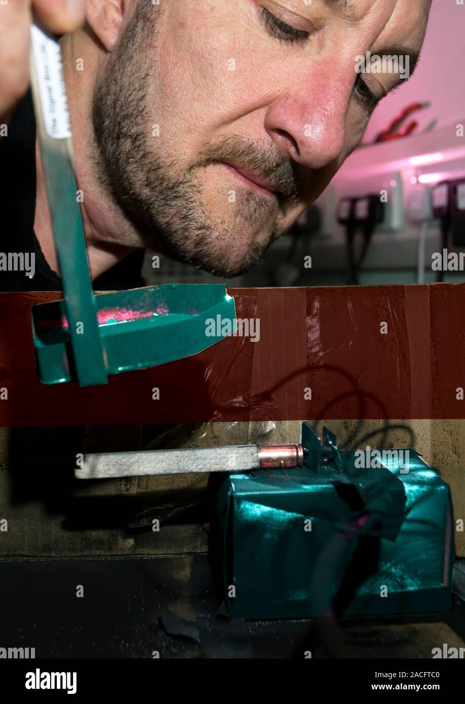 Latent finger print identification. Forensic scientist examining a ...