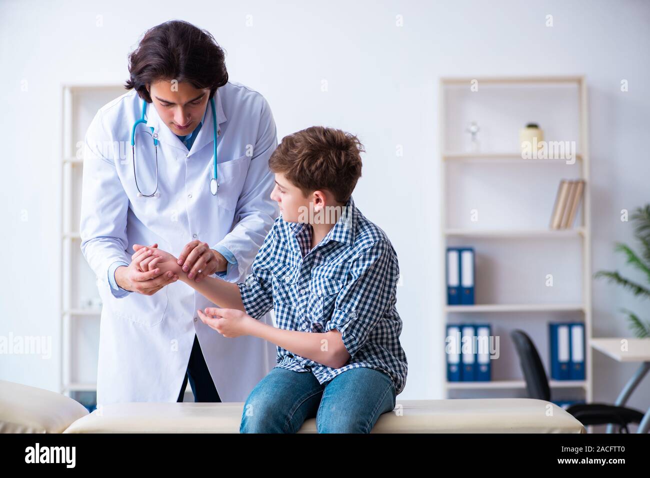 The hand injured boy visiting young male doctor Stock Photo - Alamy