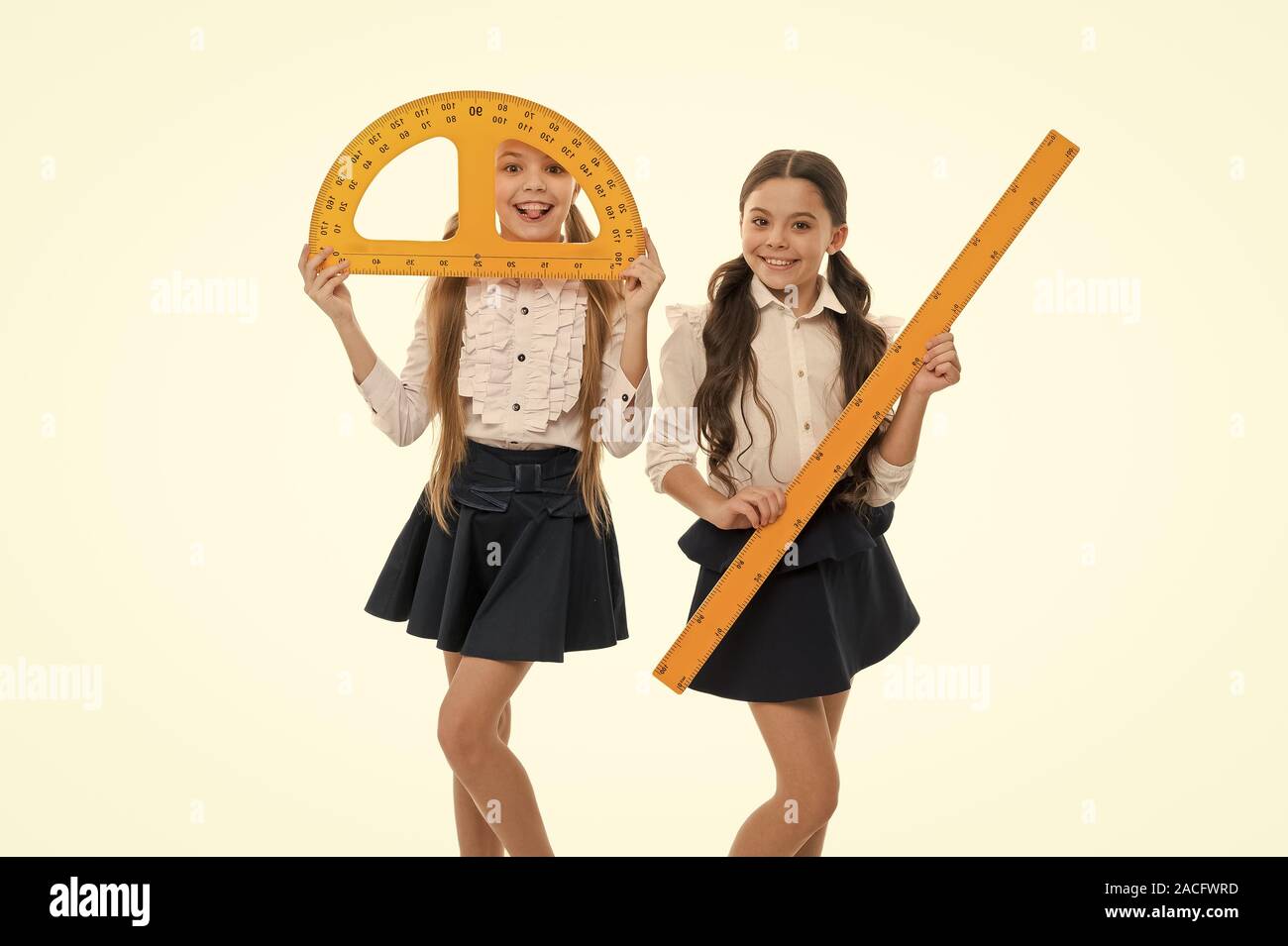 Geometry lesson is much fun. Little girls holding protractor and ruler ...