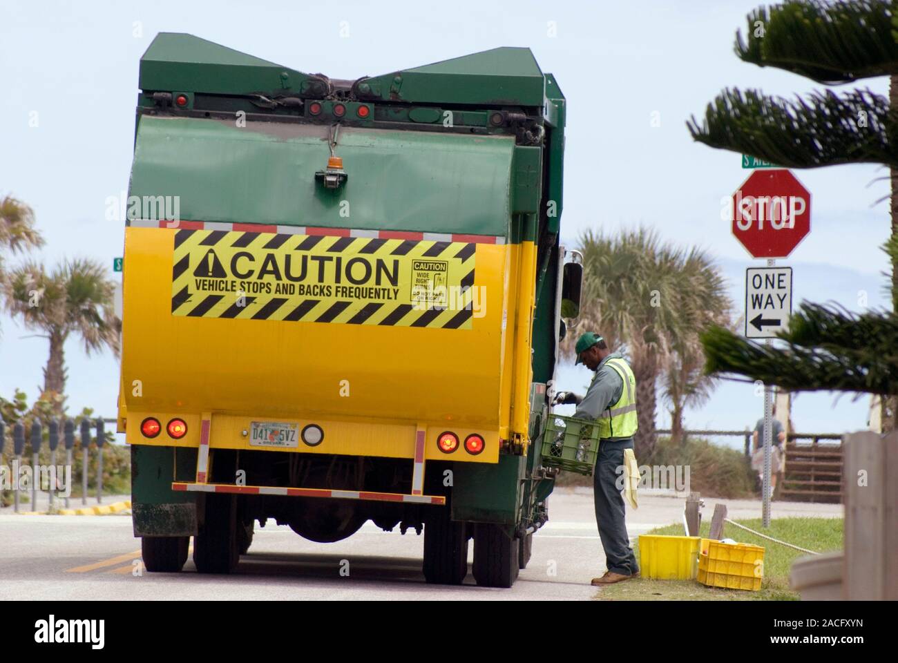 Refuse collection. Bin man sorting recyclables into a refuse collection ...