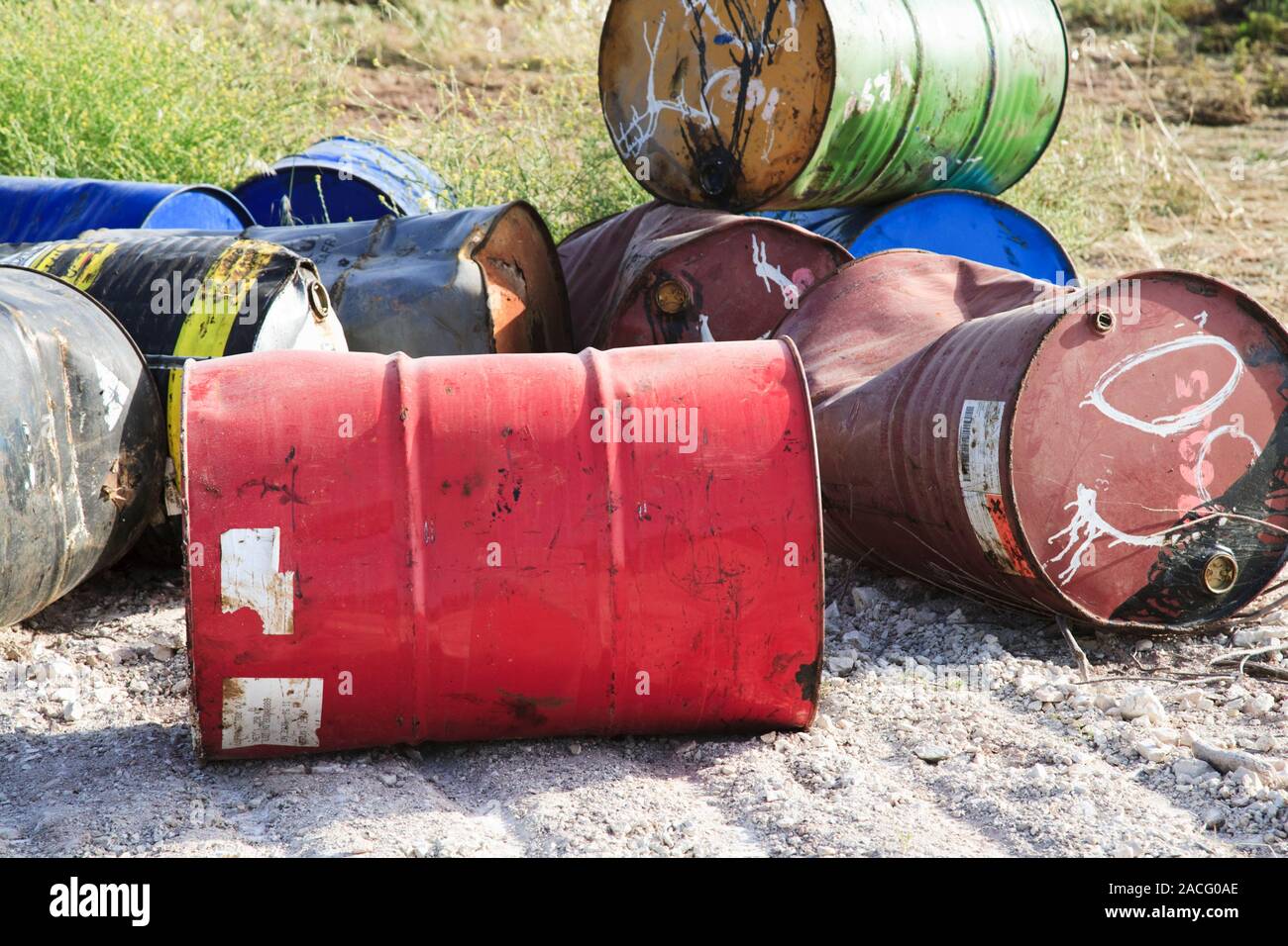 Colourful drums of waste dumped in an agricultural environment. Barrels ...
