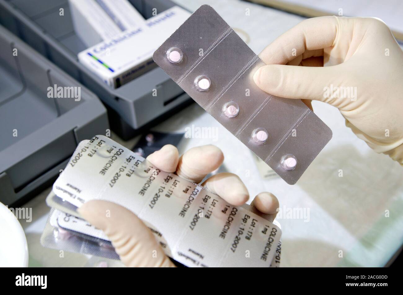 Preparing medications. Pharmacist handling packets of pills Stock Photo ...