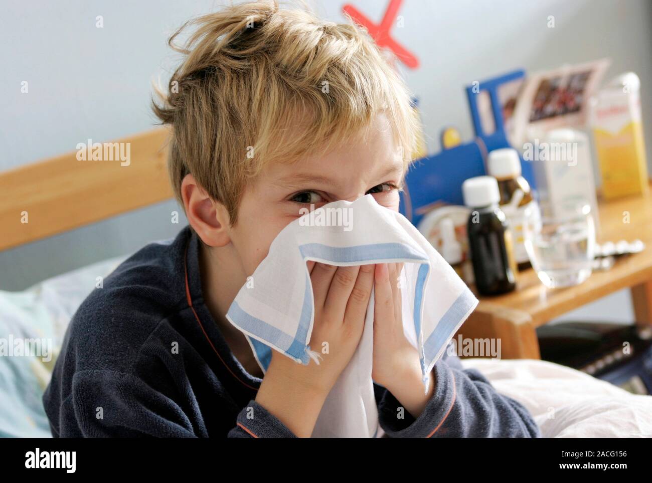 Boy blowing his nose. Boy with a cold using a handkerchief to blow his ...