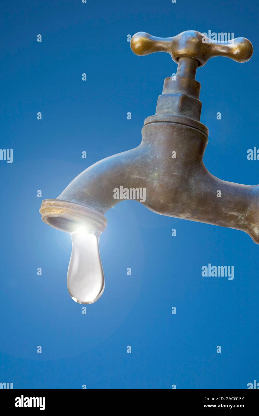 Dripping tap. Sunlight glinting from a drop of water dripping from a ...