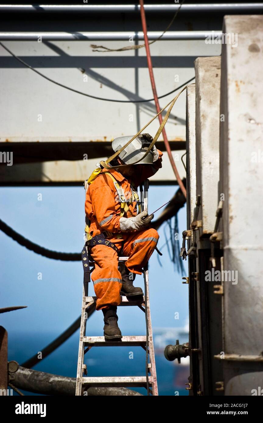 Oil industry. Worker carrying out maintenance on an oil platform. Oil ...