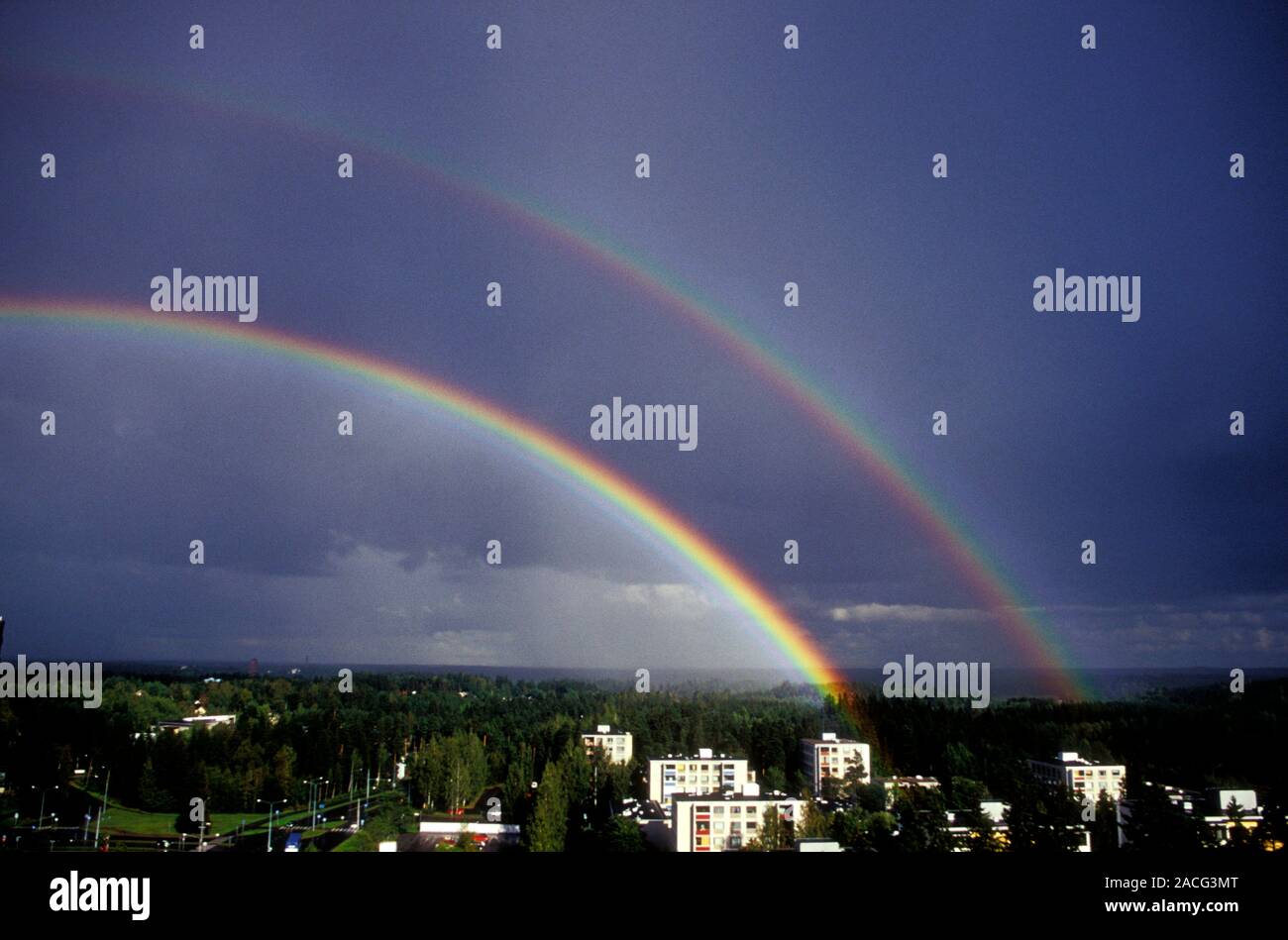 Double rainbow over a town amid trees Stock Photo - Alamy