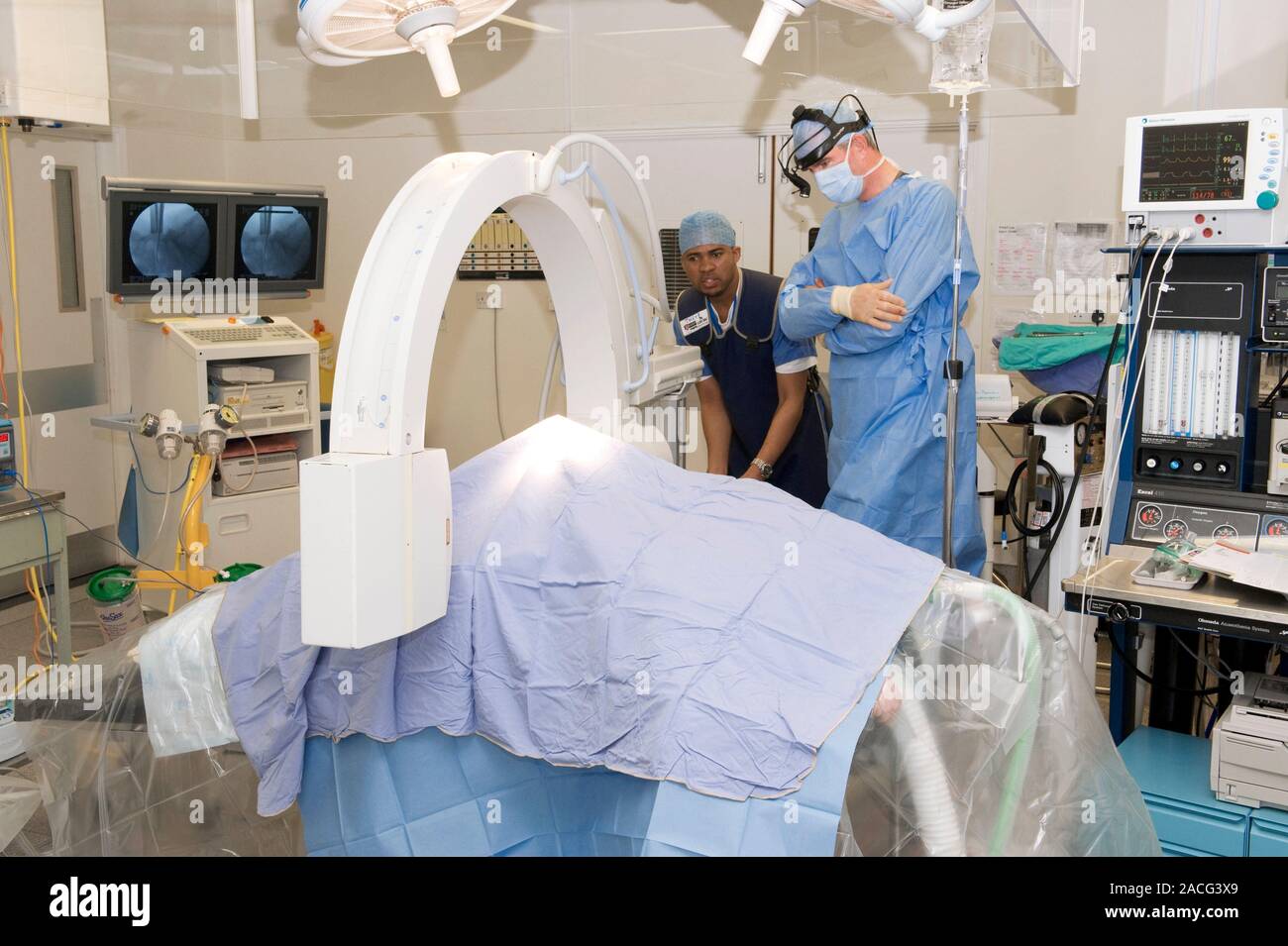 Spinal surgery. Surgeons operating on the spine of a patient with the ...