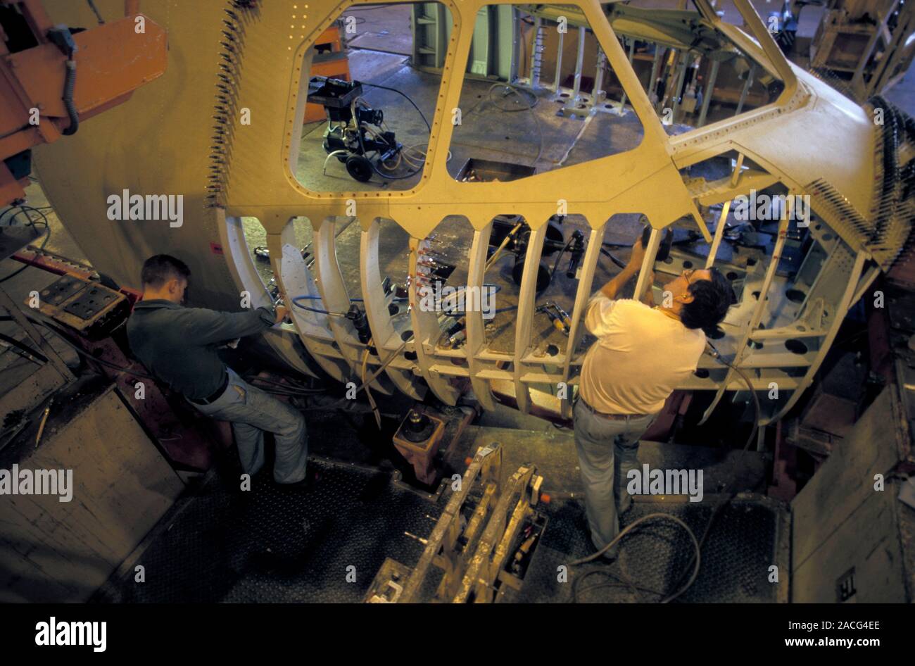 Passenger aircraft construction. Here workers are positioning and ...
