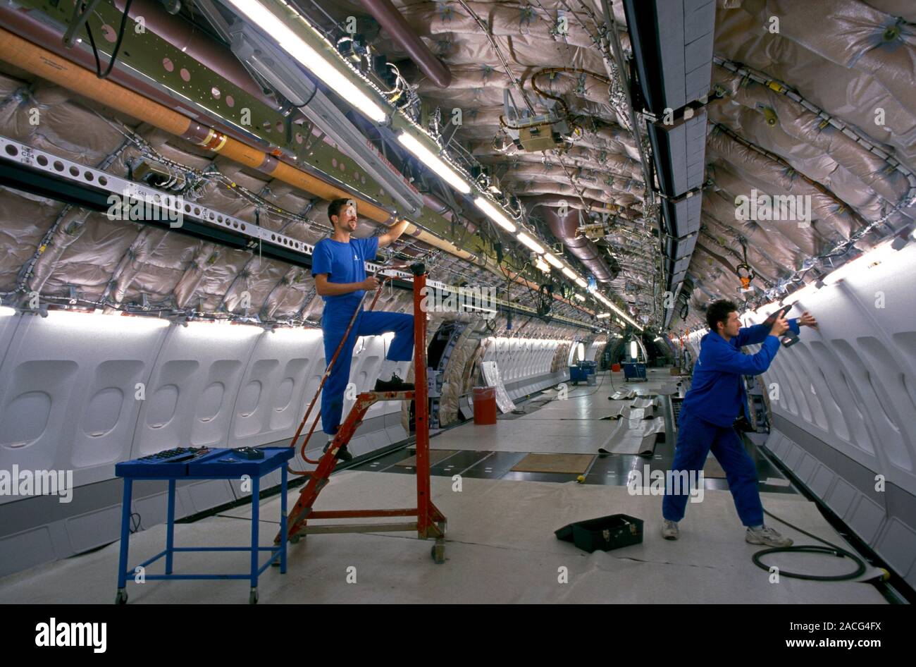 Passenger aircraft construction. Technicians fitting the cabin interior ...