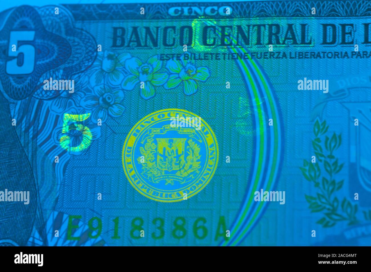 Dominican Republic banknote in UV light, close up. The design on this ...