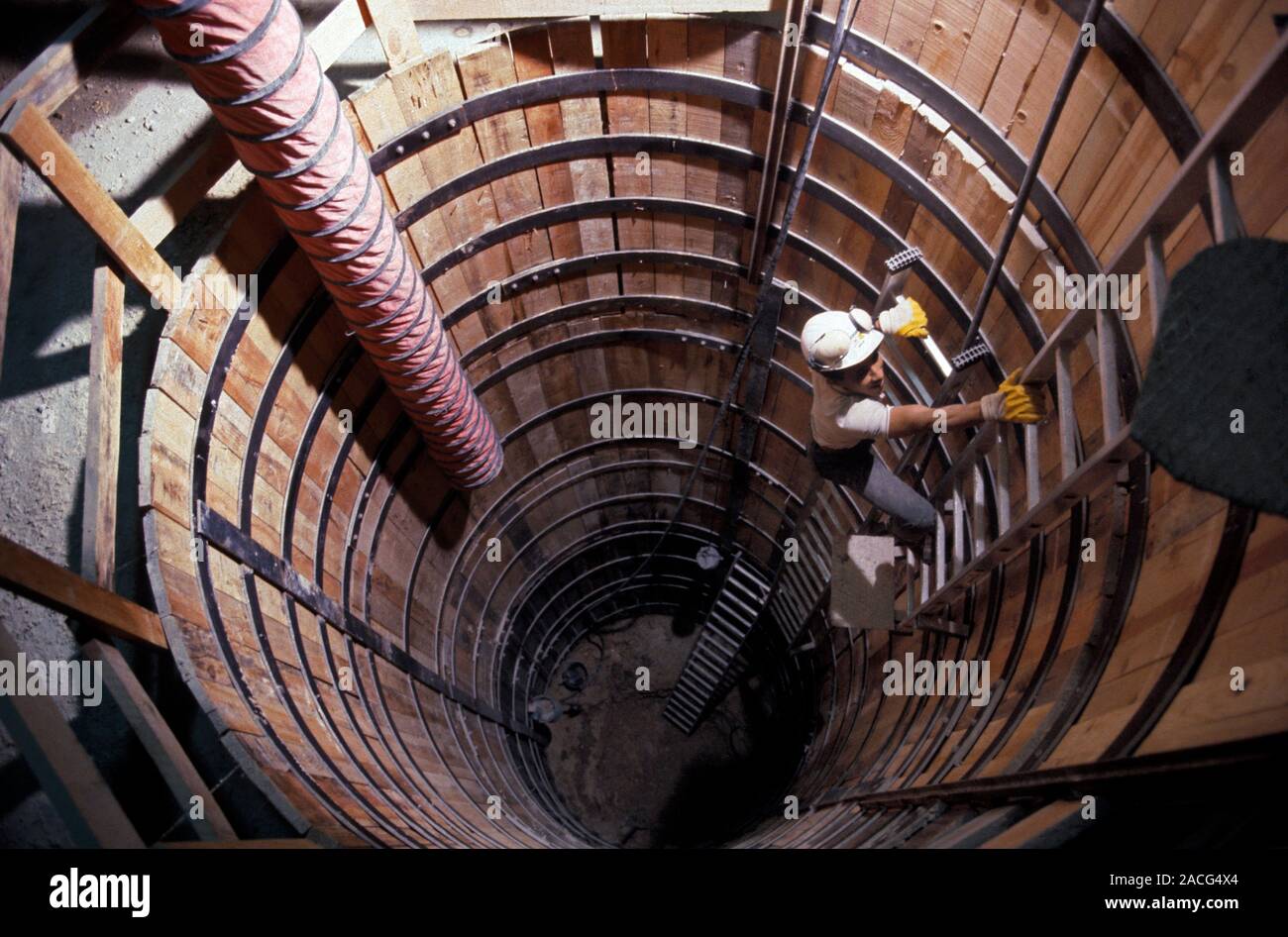 Metro train tunnel construction. Worker using ladders to ascend up a ...