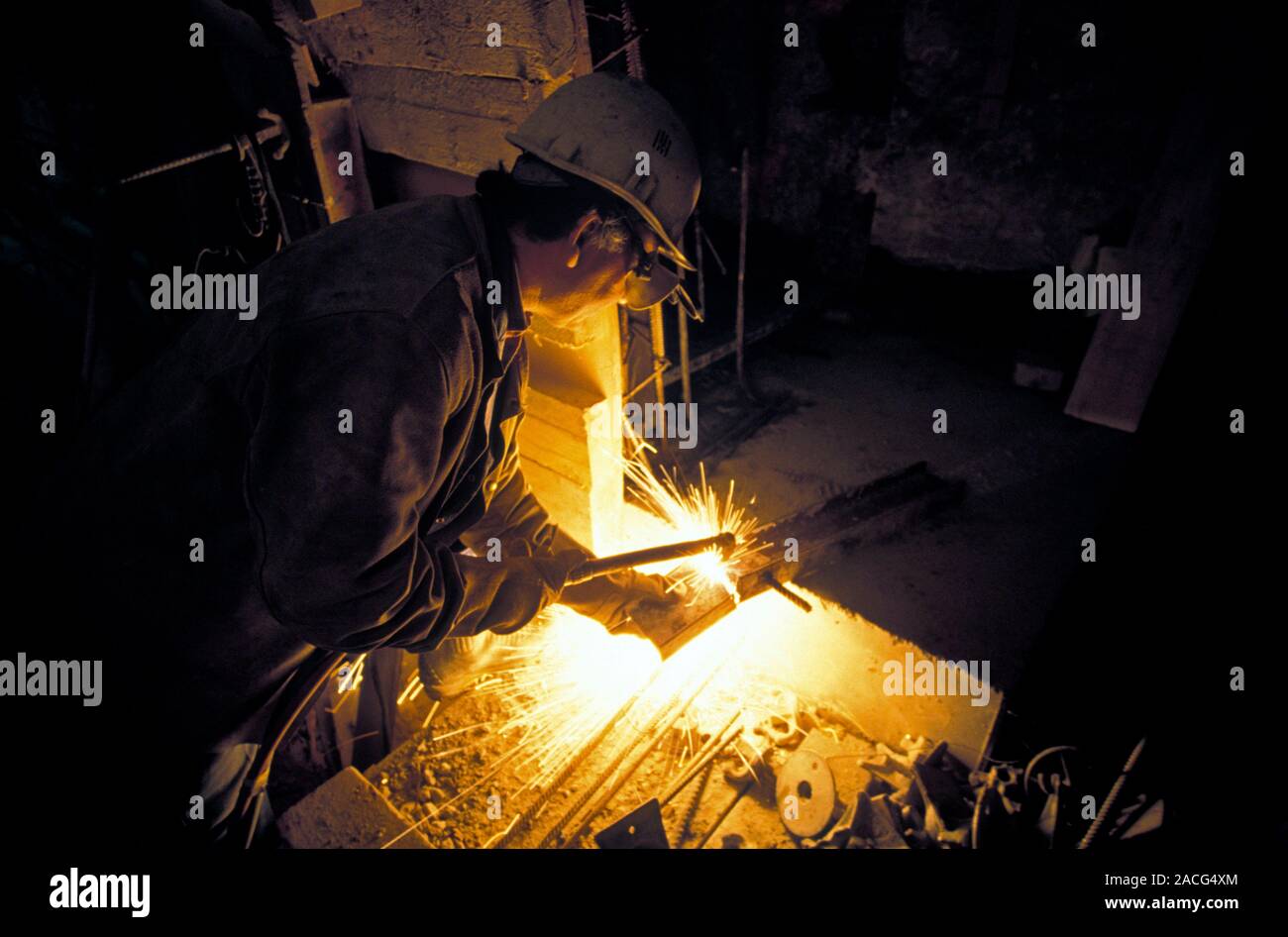 Metro train tunnel construction. Worker using a welding torch to cut a ...