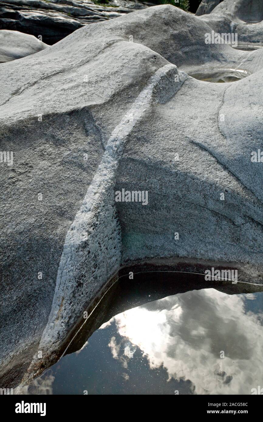 Pegmatite intrusion. Pegmatite (white band) is a type of igneous rock ...