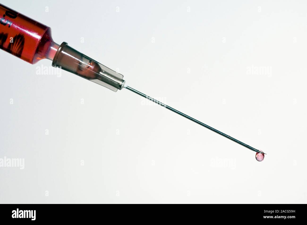 Medical syringe and hypodermic needle filled with a red liquid Stock ...