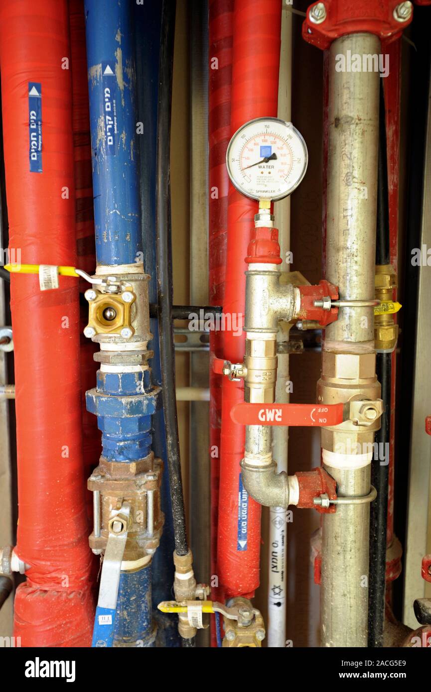 Insulated water pipes. This water supply is colour-coded: red for hot ...
