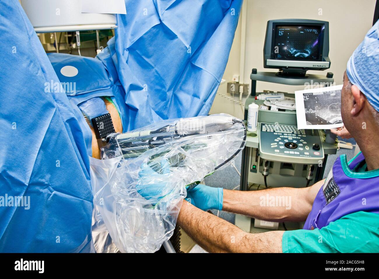 Prostate cancer radiotherapy surgery. Radiologist positioning a trans ...