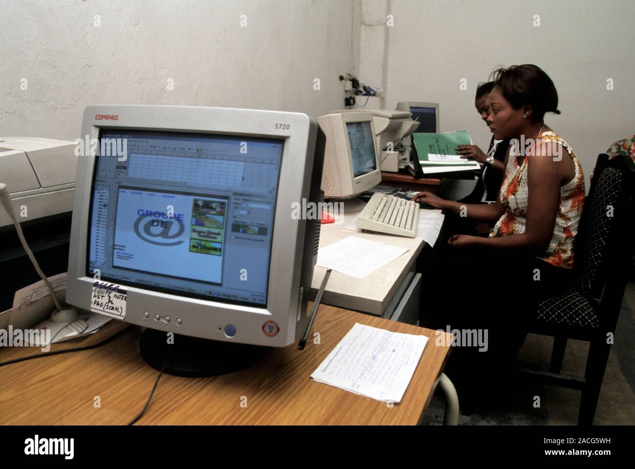 Adult education. Woman being taught how to use a computer. Photographed ...