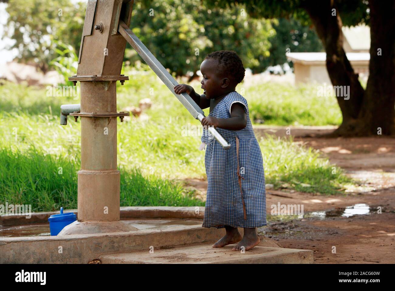 Young girl pumping water from a well. Photographed in Uganda Stock ...